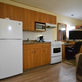 Fridge, stove and microwave in kitchenette unit